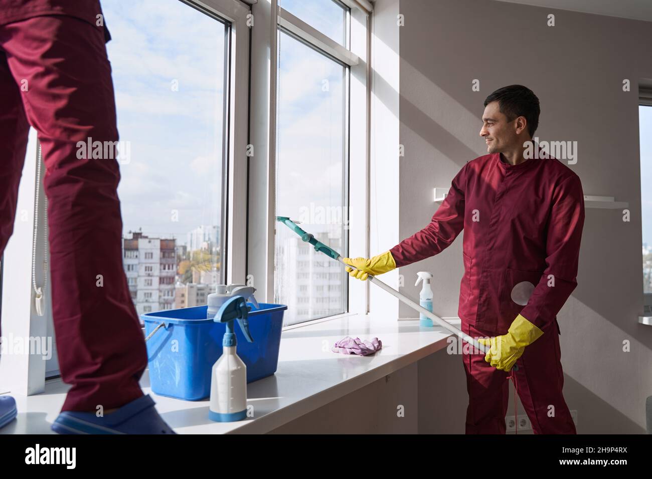 Experienced janitorial personnel in uniforms washing window Stock Photo ...