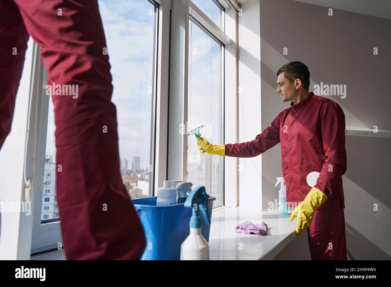 Uniformed professional janitorial staff washing large window Stock ...