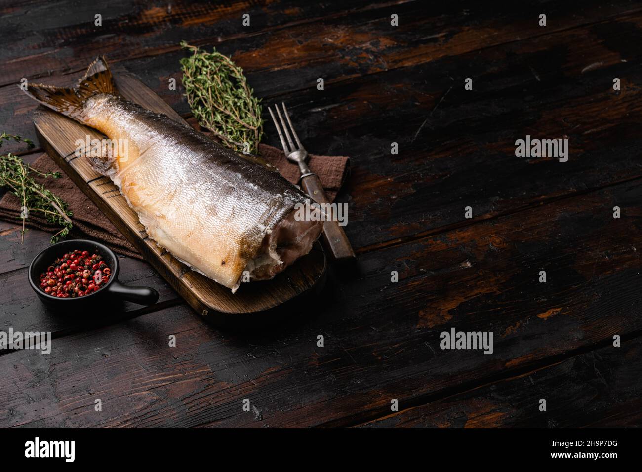 Smoked whole trout set, on old dark wooden table background, with copy ...