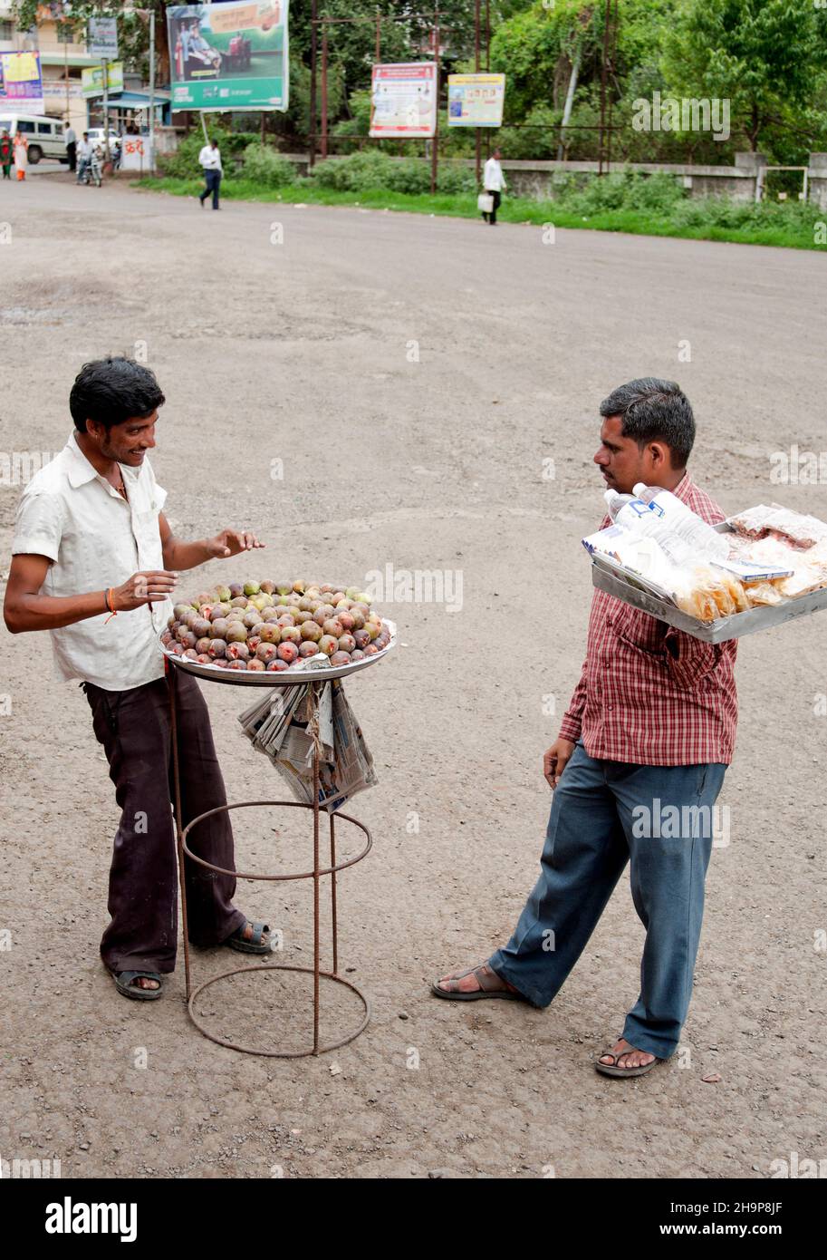 Two vendor talking each other at bus stand Stock Photo - Alamy