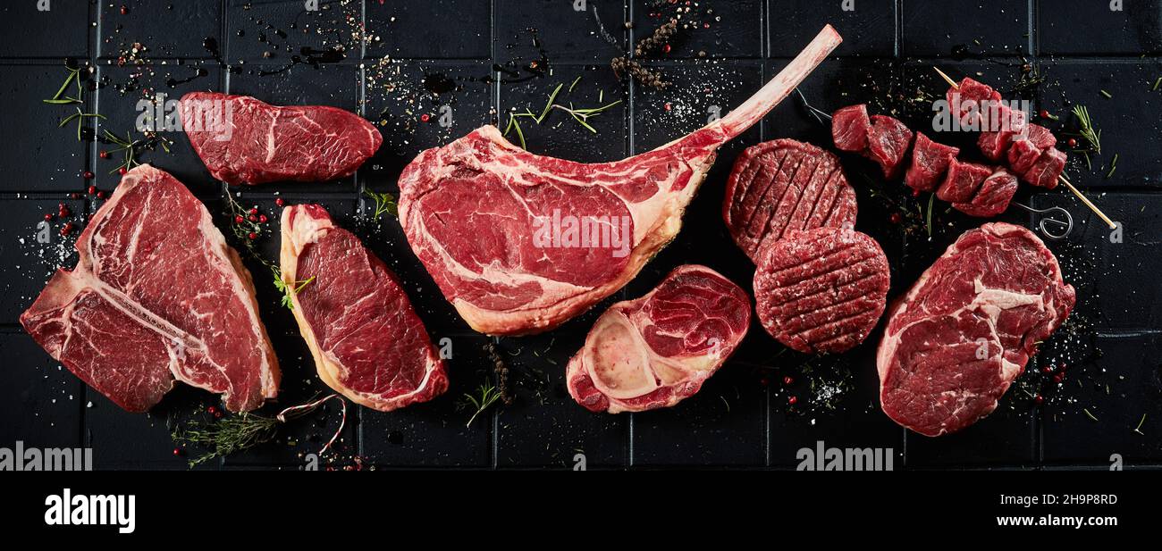 Top view of set of various uncooked stakes including t bone tomahawk ...