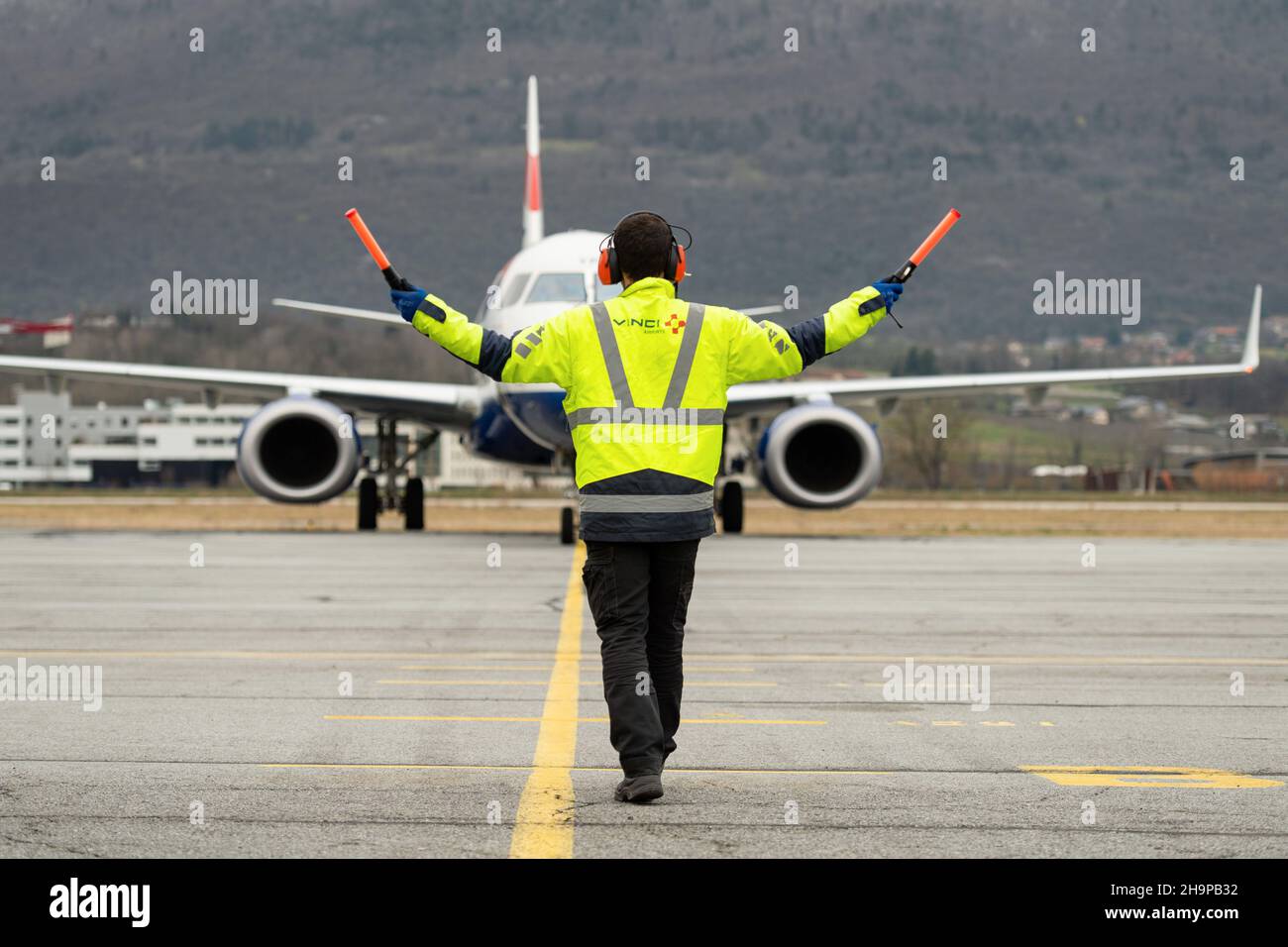 Vinci Airports ground crew member giving commands to an airplane on the ...