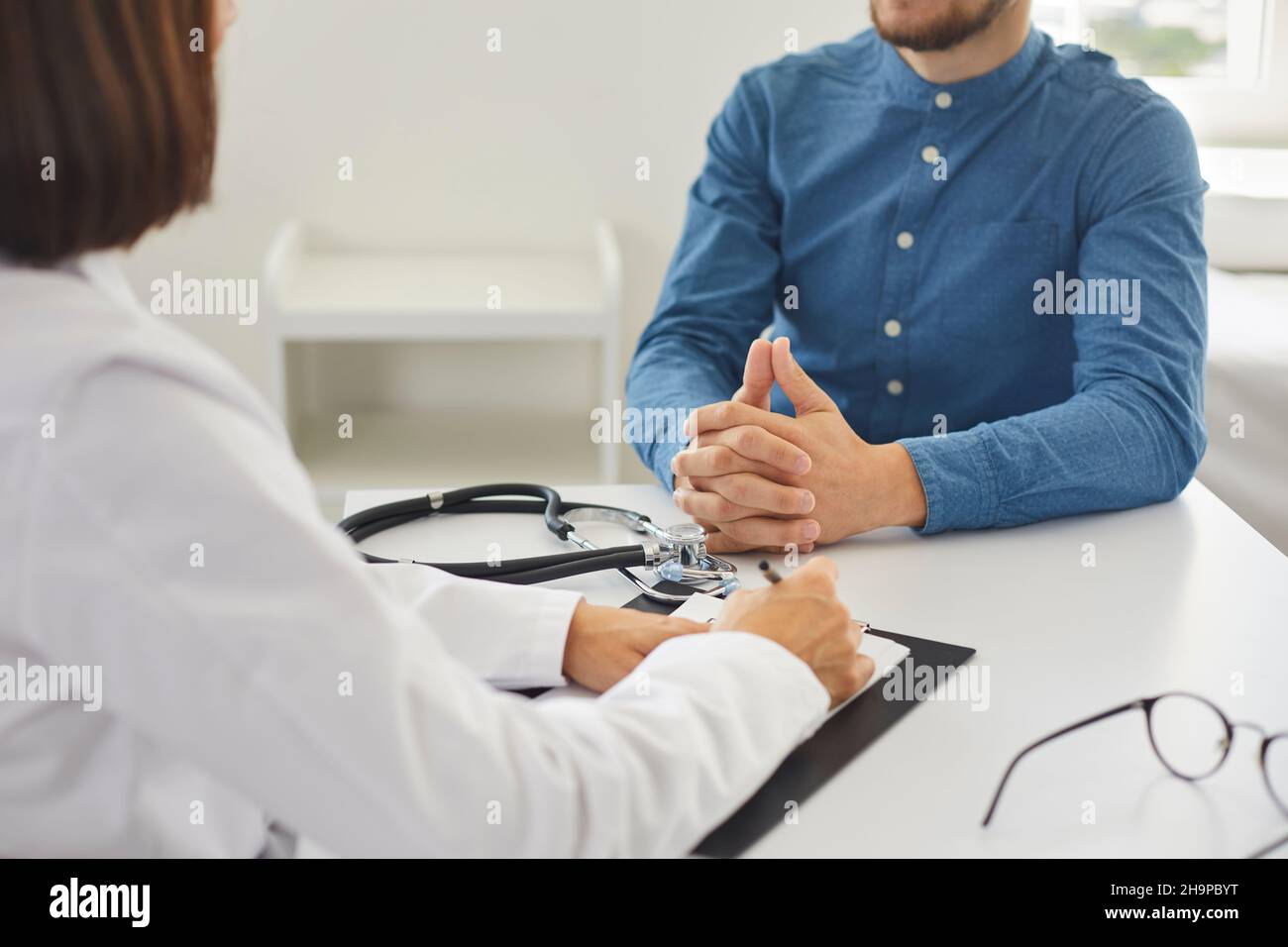 Patient having conversation with professional physician sitting at ...