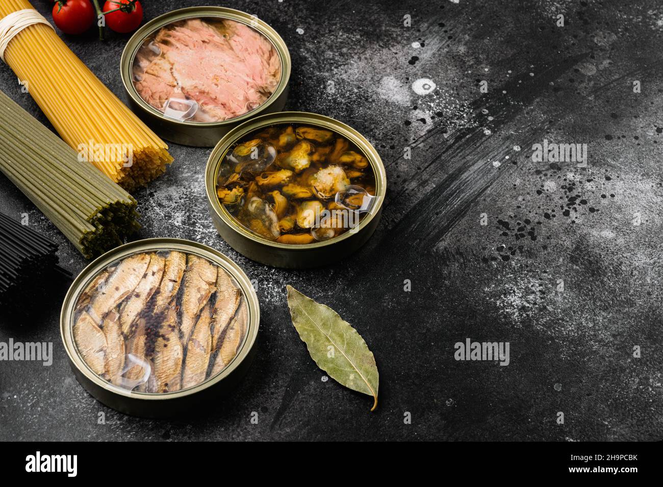 Variety of Seafood tuna mussel fish tin cans set, on black dark stone ...