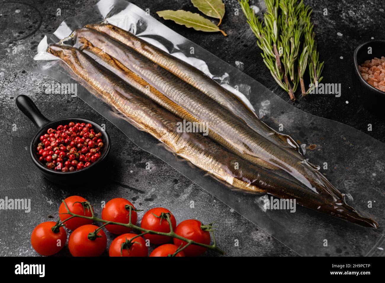 Grilled lamprey vacuum pack set, on black dark stone table background ...