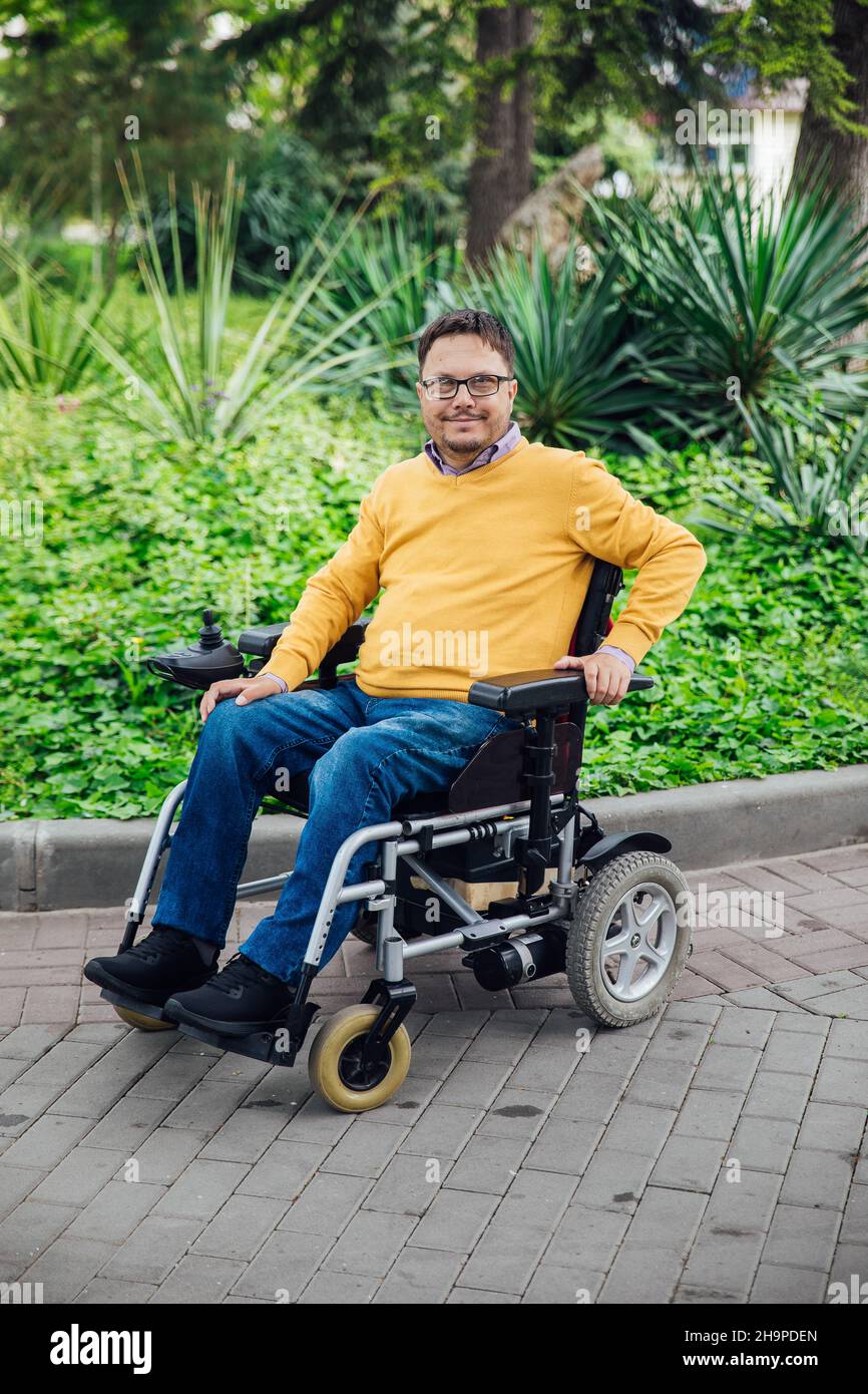 a man with disabilities in a wheelchair walks the city Stock Photo - Alamy