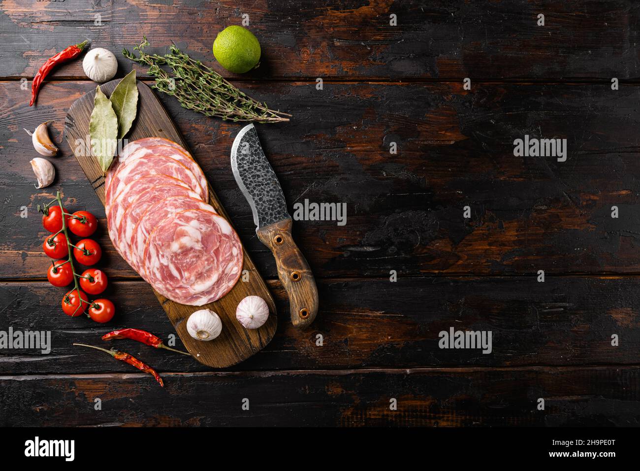Smoked sausage slices, thinly sliced set, on old dark wooden table ...