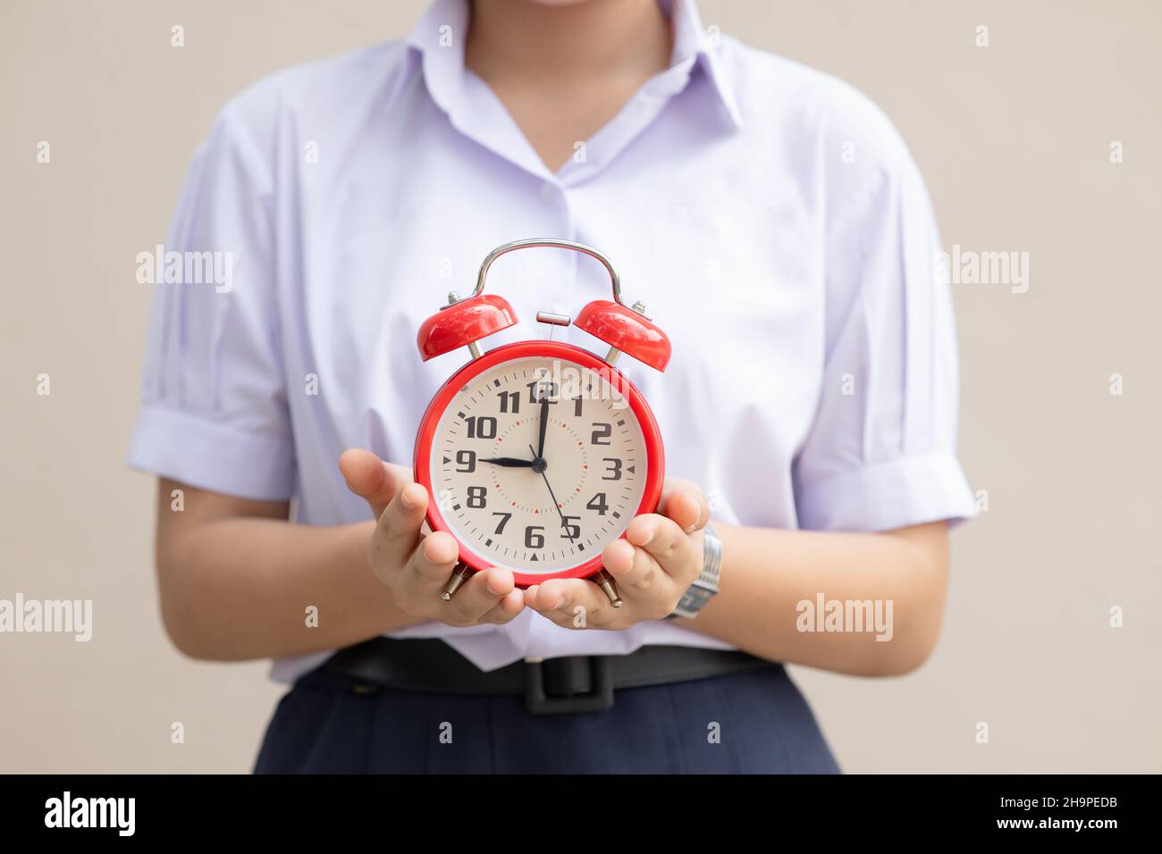 Student with uniform hand holding alarm clock for Time to learning and ...