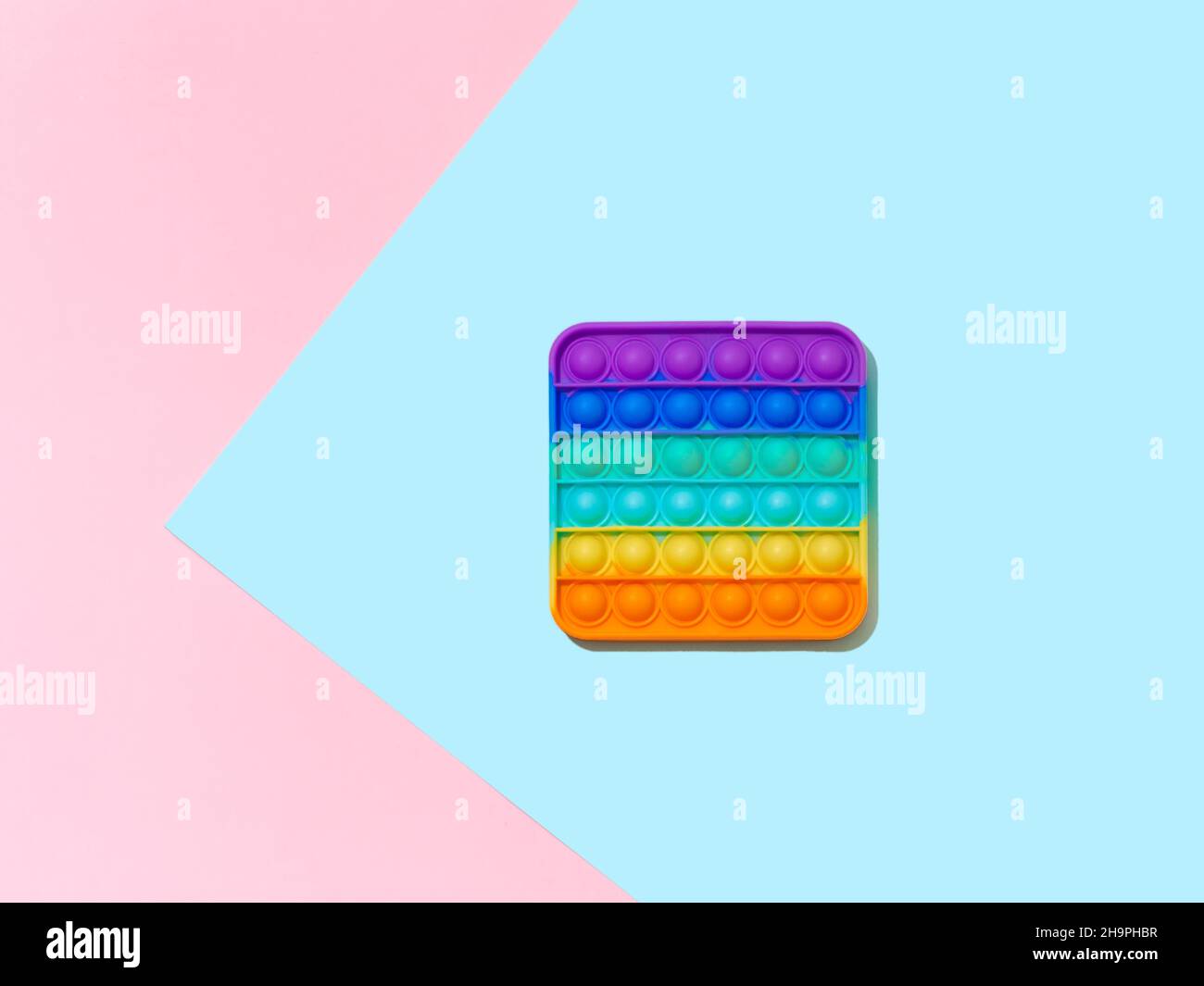 Popit or simple dimple toy on blue and pink background with copy space ...