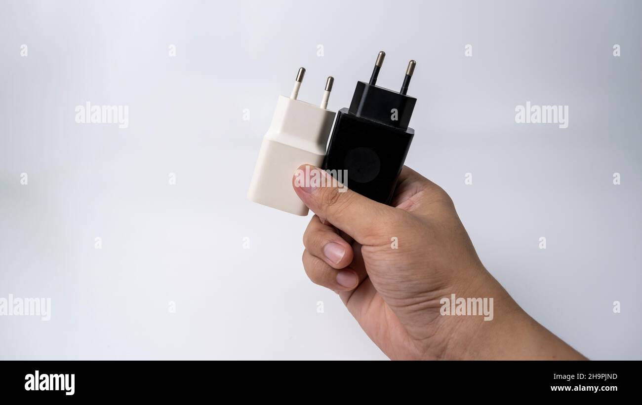 This is a black and white smartphone charger on a white background. It ...