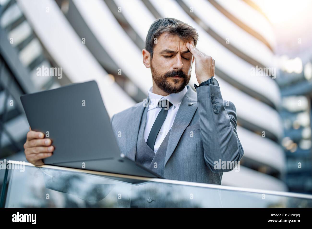 Frustrated young businessman working on laptop. Stressed businessman ...