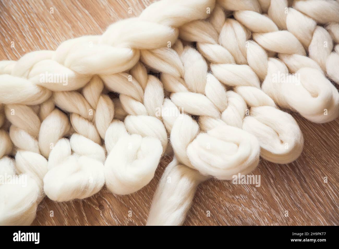 The process of knitting a plaid of large knitting from merino wool ...