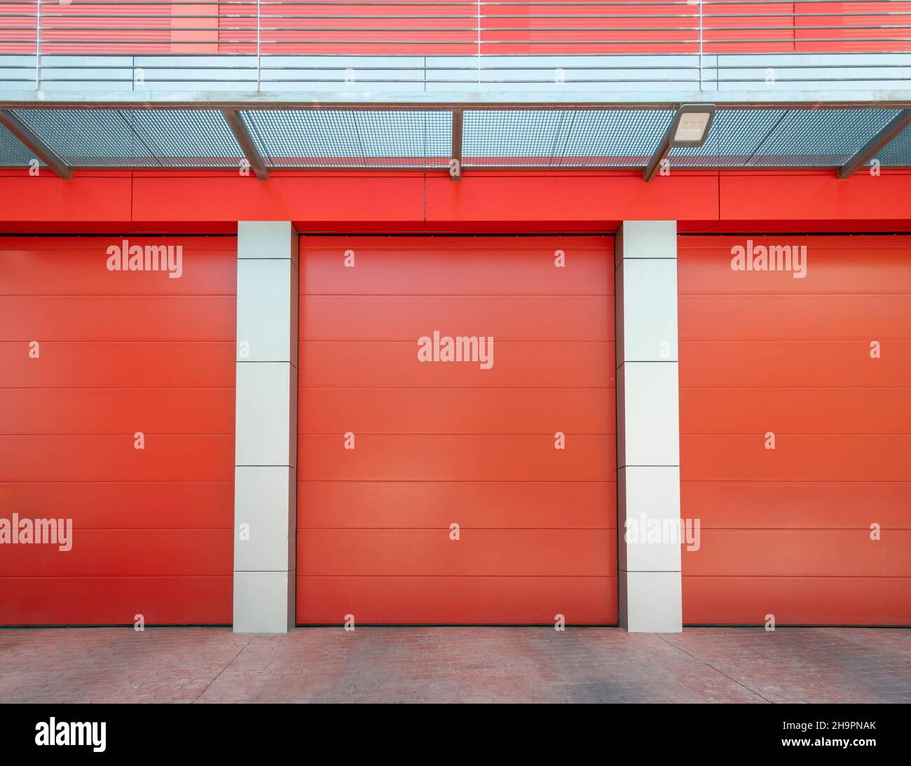 Red warehouse with closed roller shutter door Stock Photo - Alamy