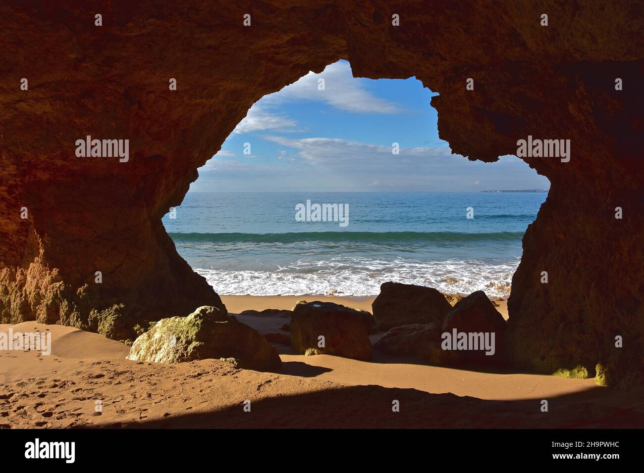 View of the sea through a rock window, sandy beach, cliffs, Algarve ...
