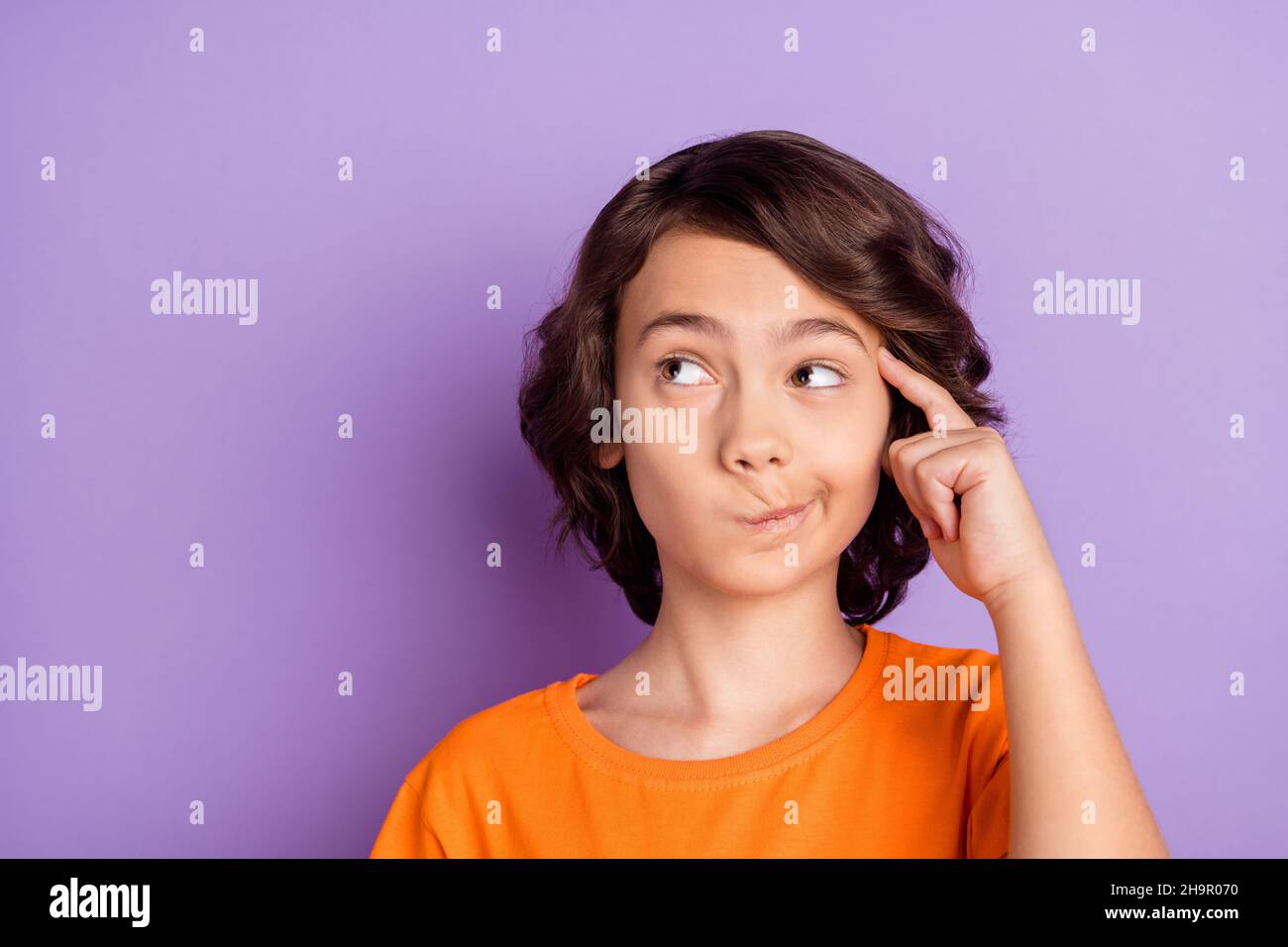 Portrait of nice unsure bewildered boy touching temple overthinking ...