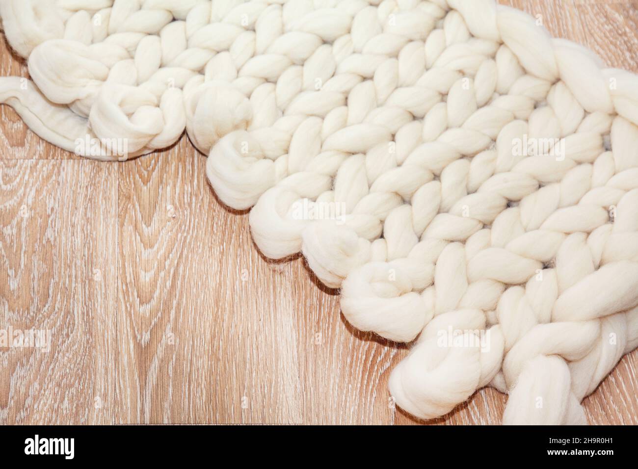 The process of knitting a plaid of large knitting from merino wool ...