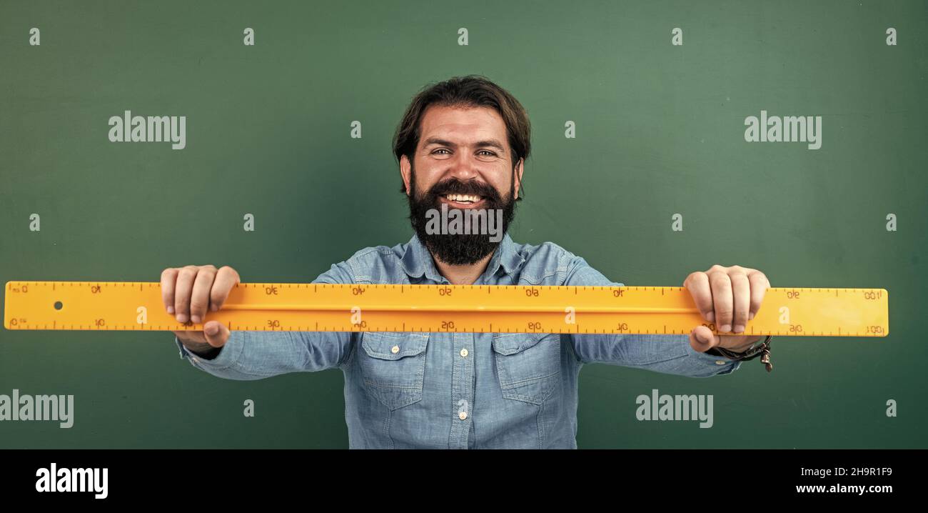 bearded man work in classroom with ruler. prepare for geometry exam ...