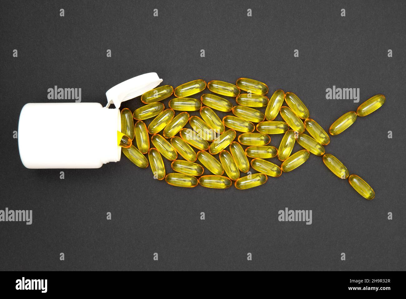 Omega-3 fish oil softgels arranged into a fish shape swimming inside a ...