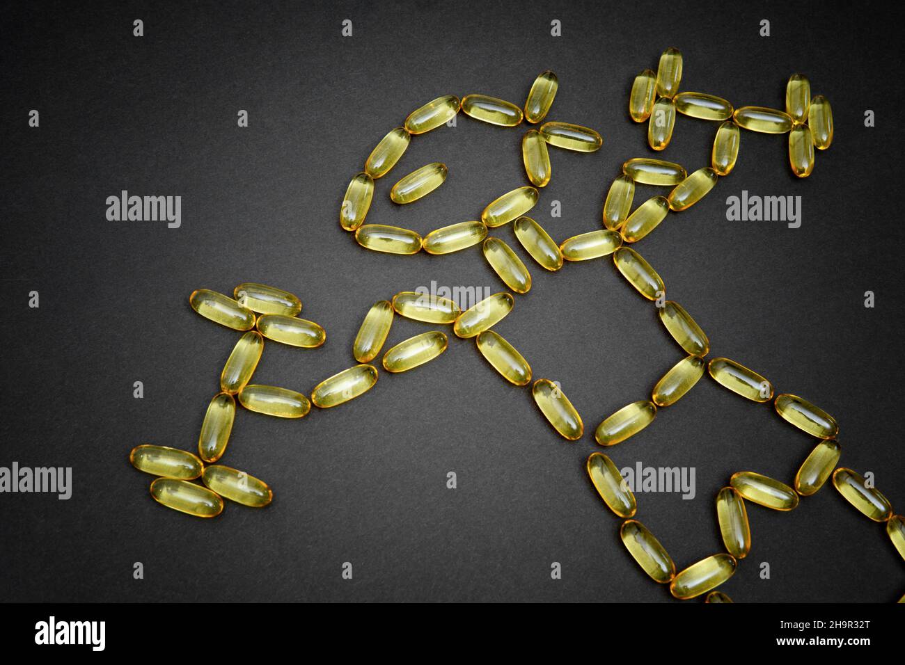 Omega-3 fish oil soft gels arranged into a bodybuilder character ...