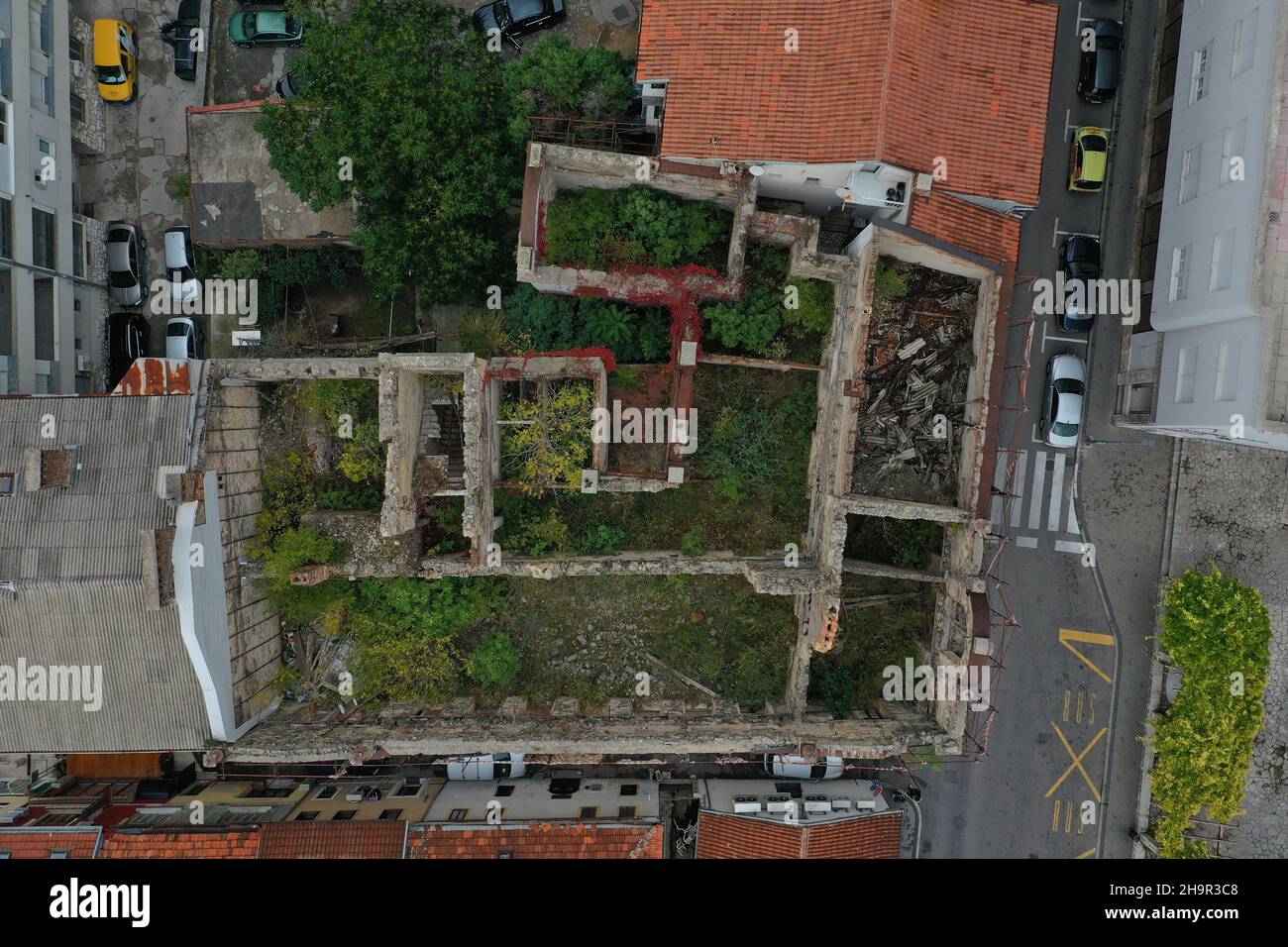 Aerial view of a roofless abandoned building and cars in the street ...
