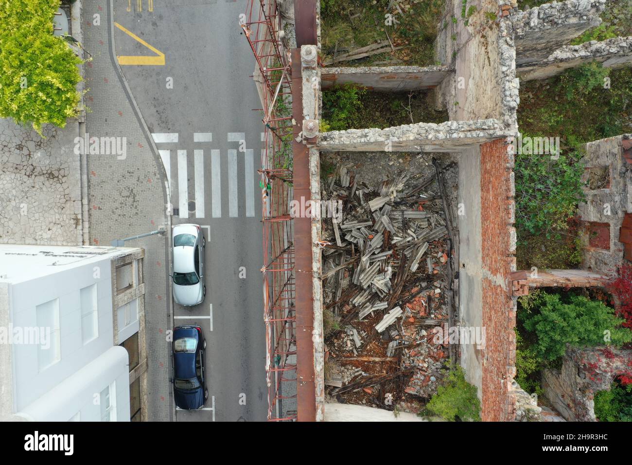 Aerial view of a roofless abandoned building and cars in the street ...