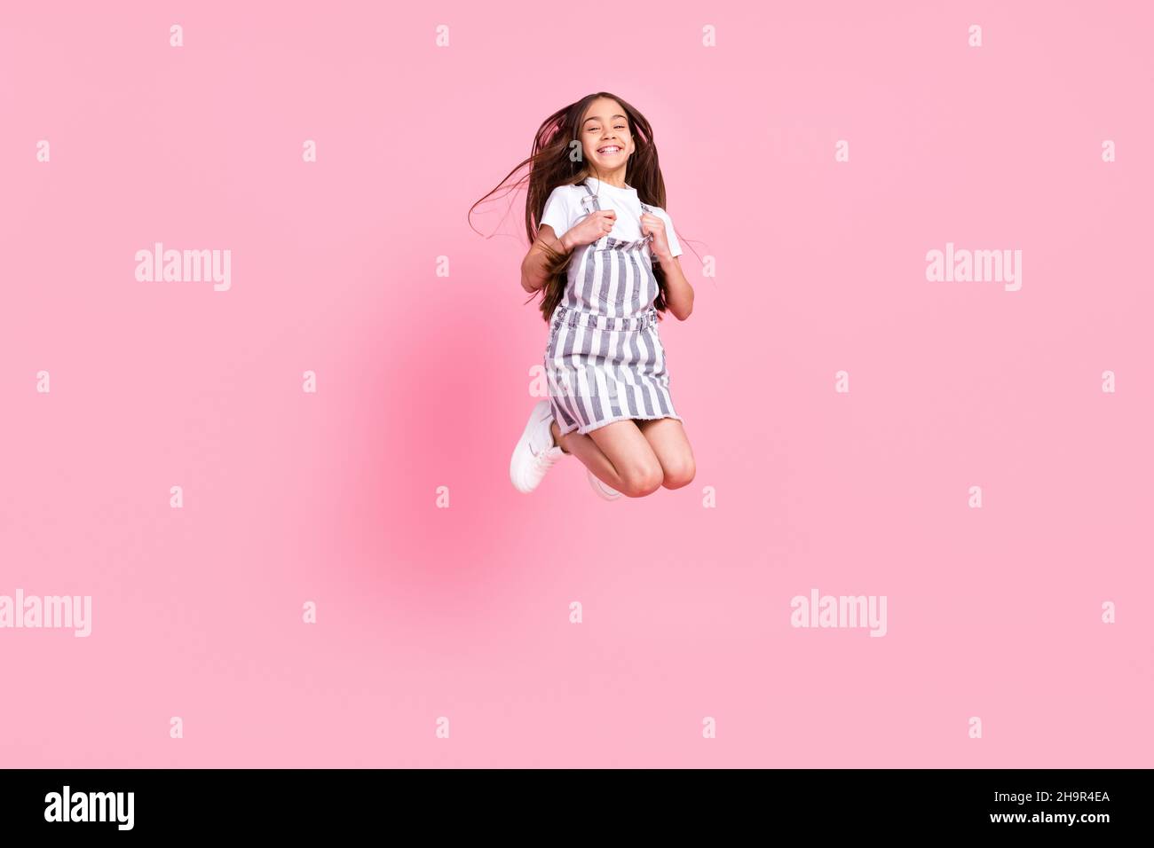 Full body photo of active funky happy little girl jump up air smile positive isolated on pastel ...