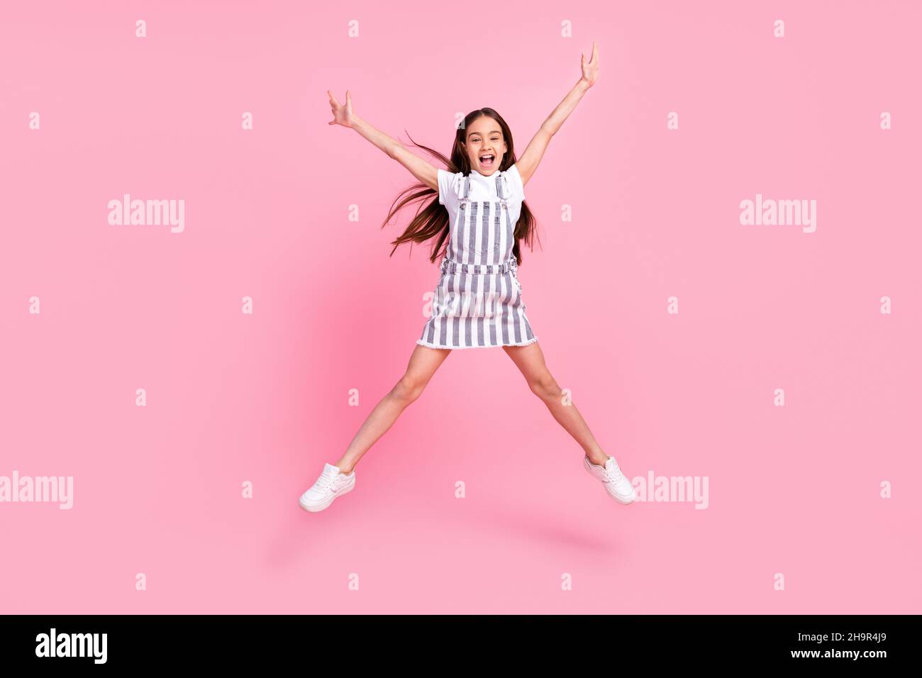 Full length photo of cheerful happy little girl jump up air star shape good mood isolated on ...