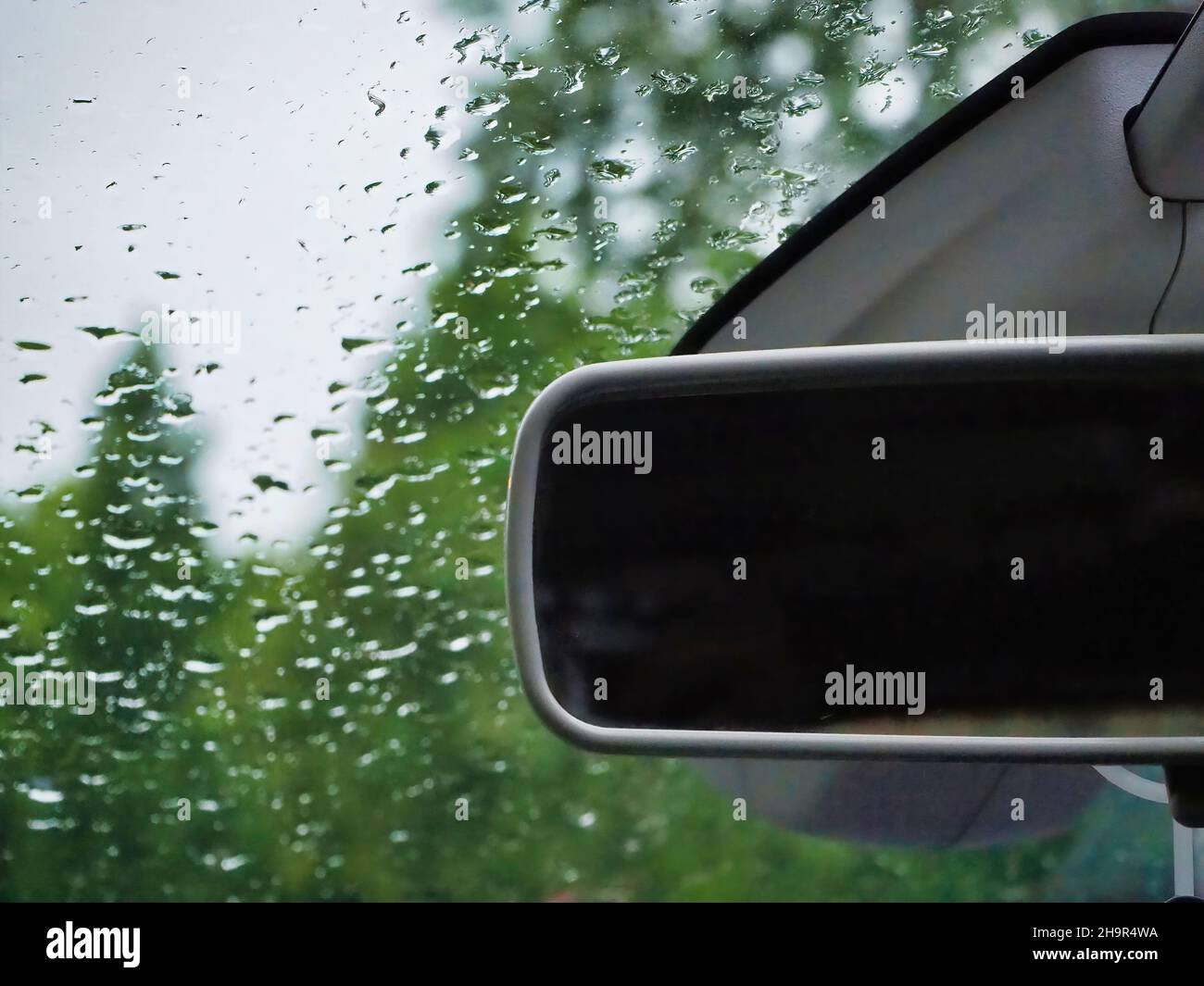 Rainy day view out the car window with water droplets on the glass ...