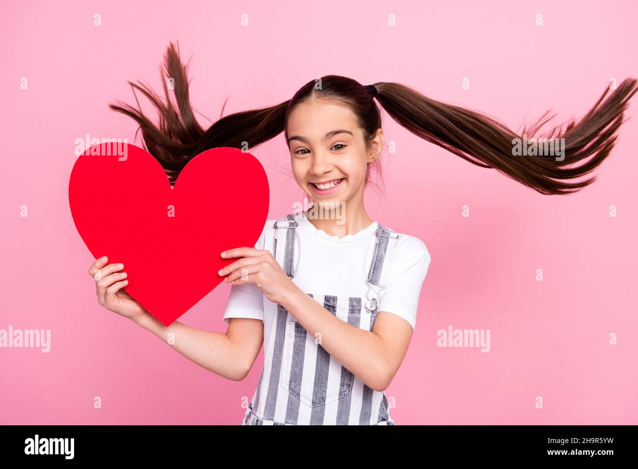 Photo of adorable happy pretty little girl good mood hold hands heart ...