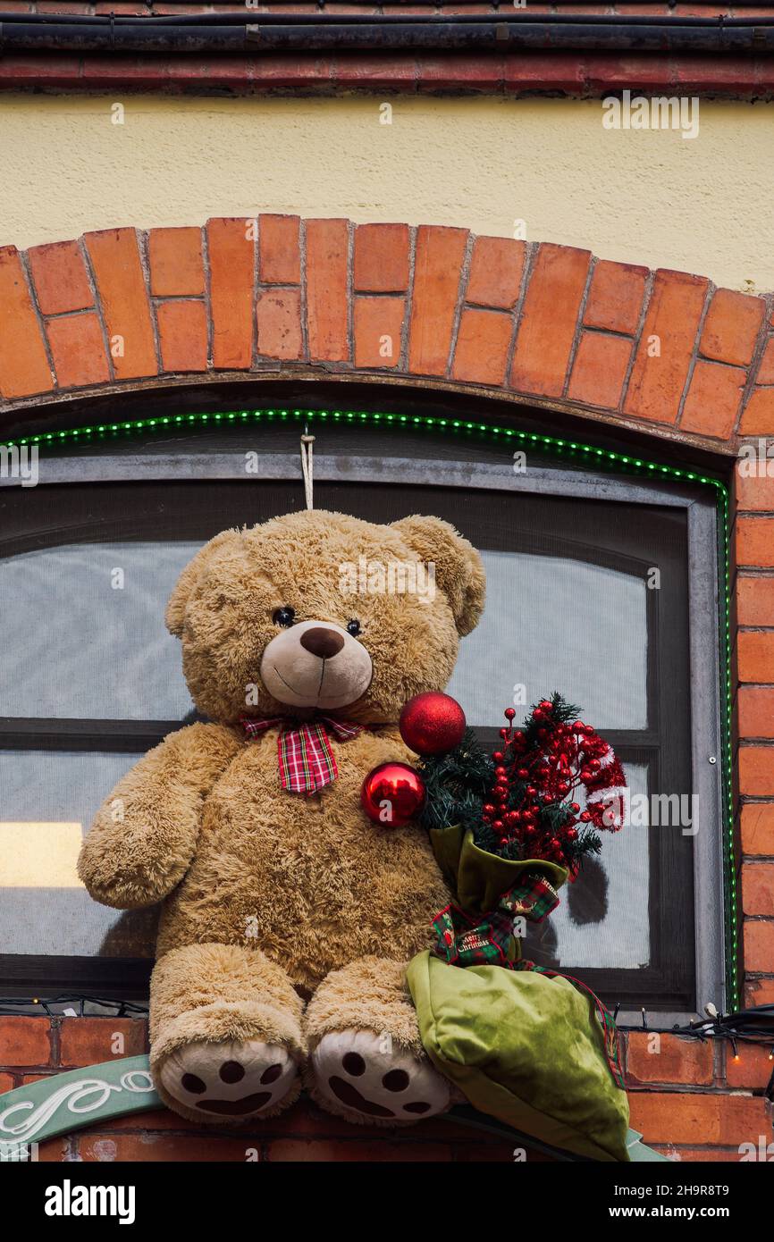 Large stuffed teddy bear outside a window. Seasonal toy figure used as ...