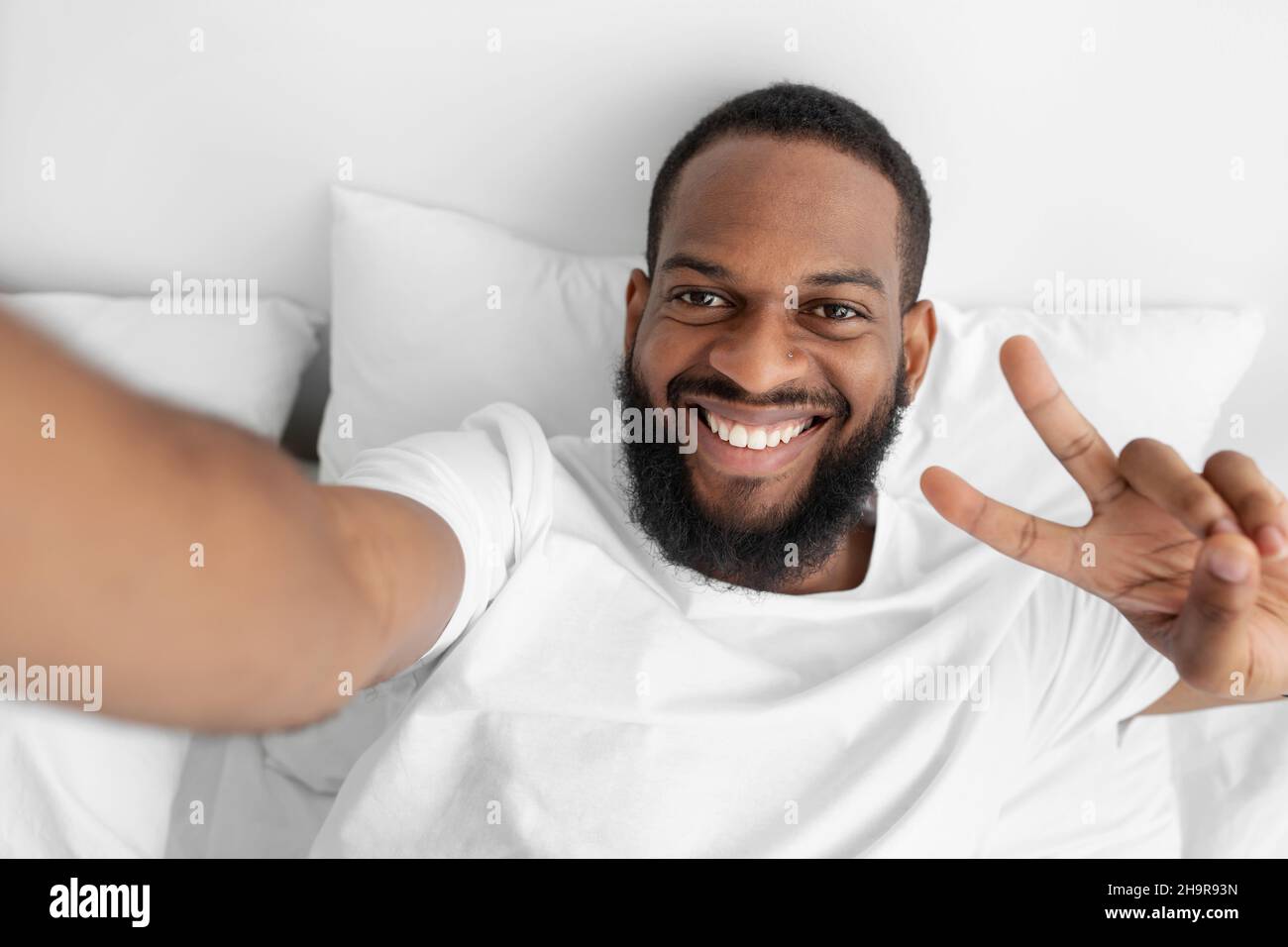 Man smiling peace sign hi-res stock photography and images - Alamy