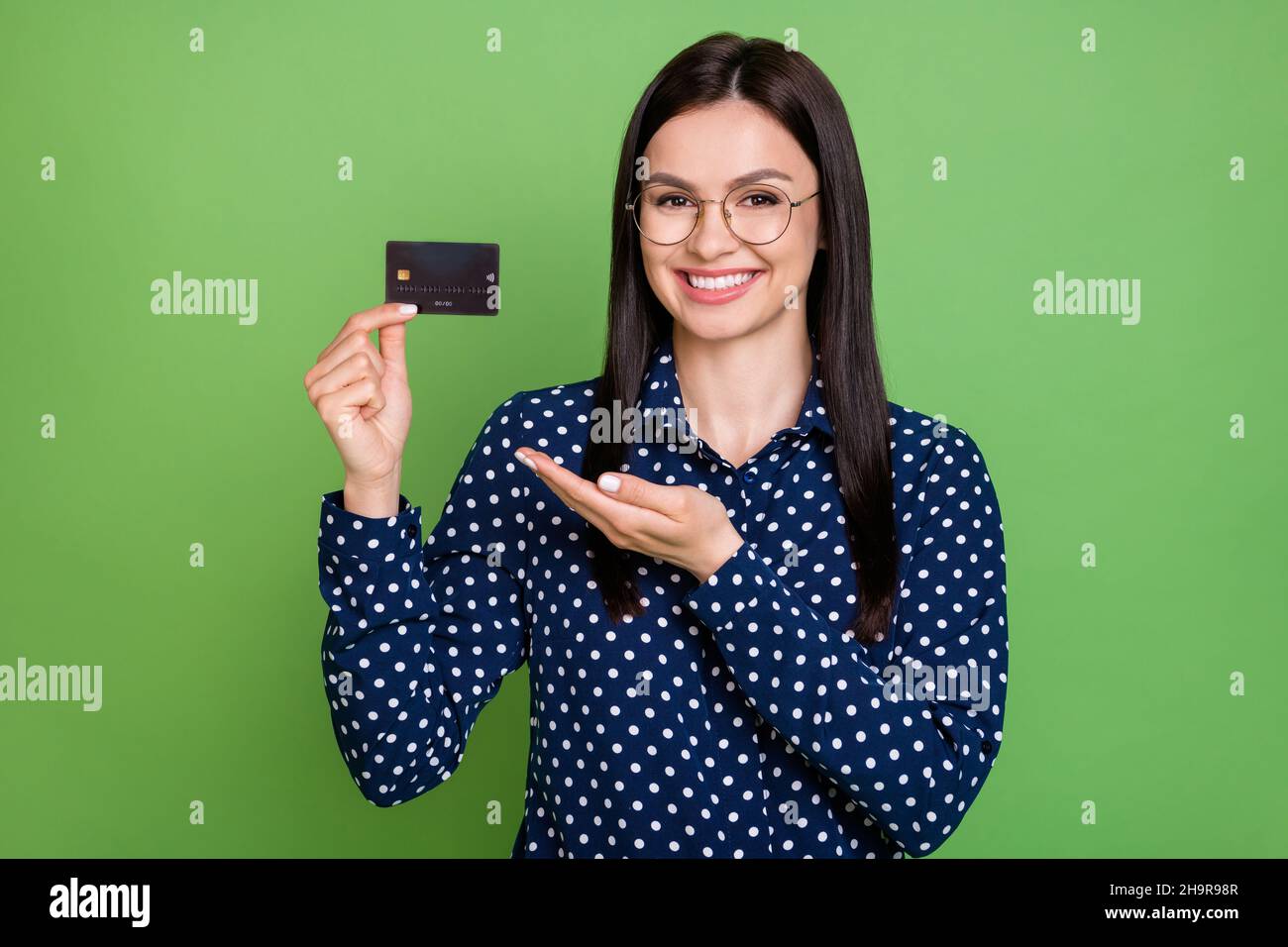 Photo of happy brunette young woman hold hand present credit card smile ...