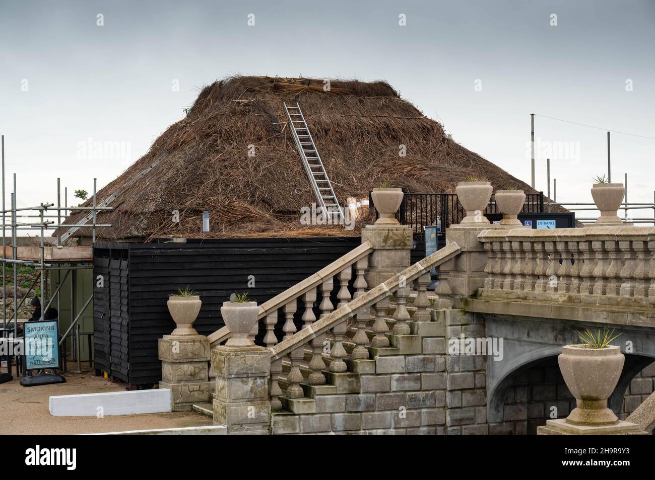 Thatched roof on a building being repaired with new thatch in Norfolk ...