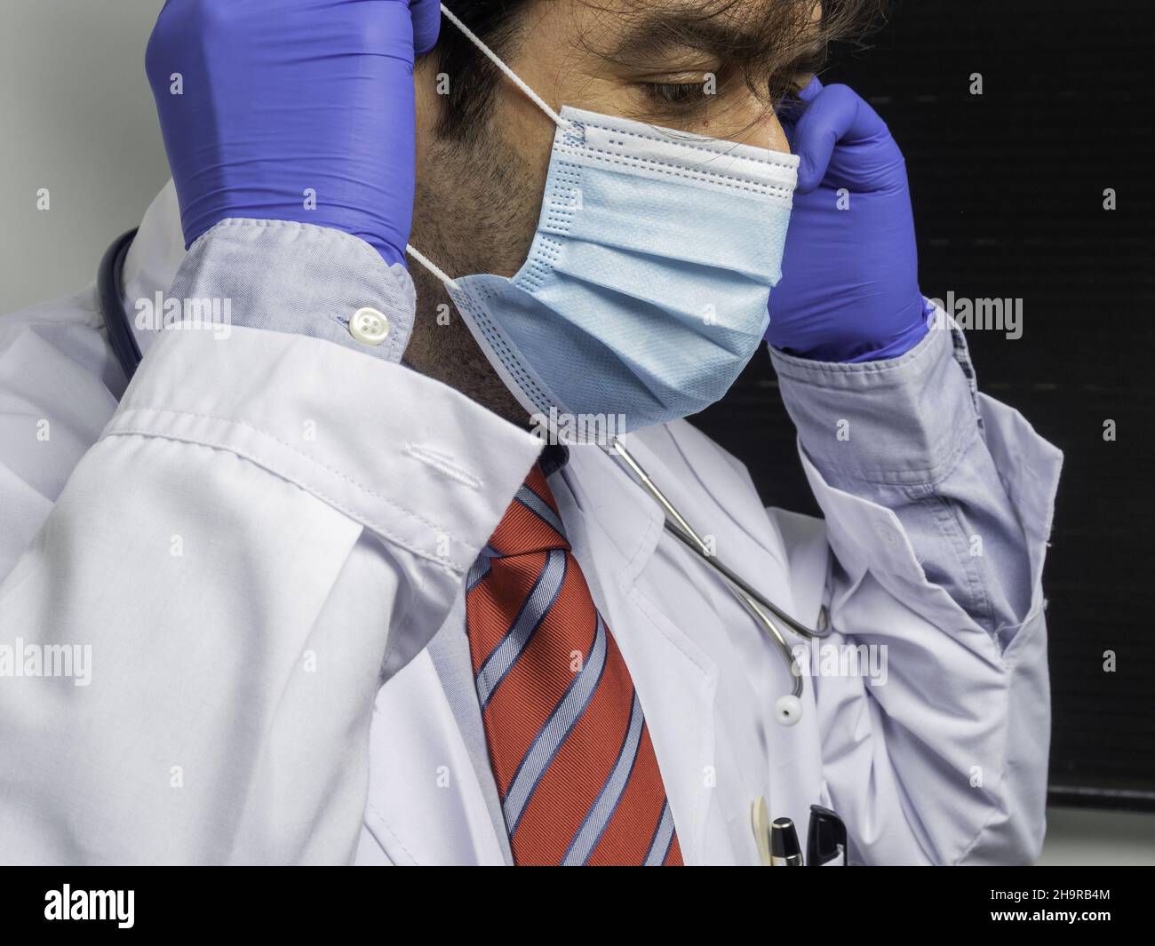 Physician putting on protective mask Stock Photo - Alamy