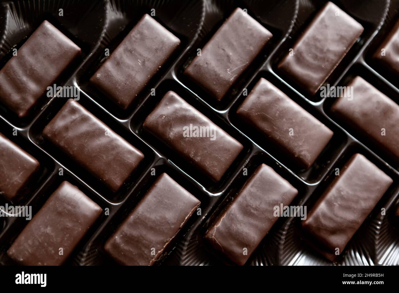 Chocolate candies in a row . Box with sweets Stock Photo - Alamy