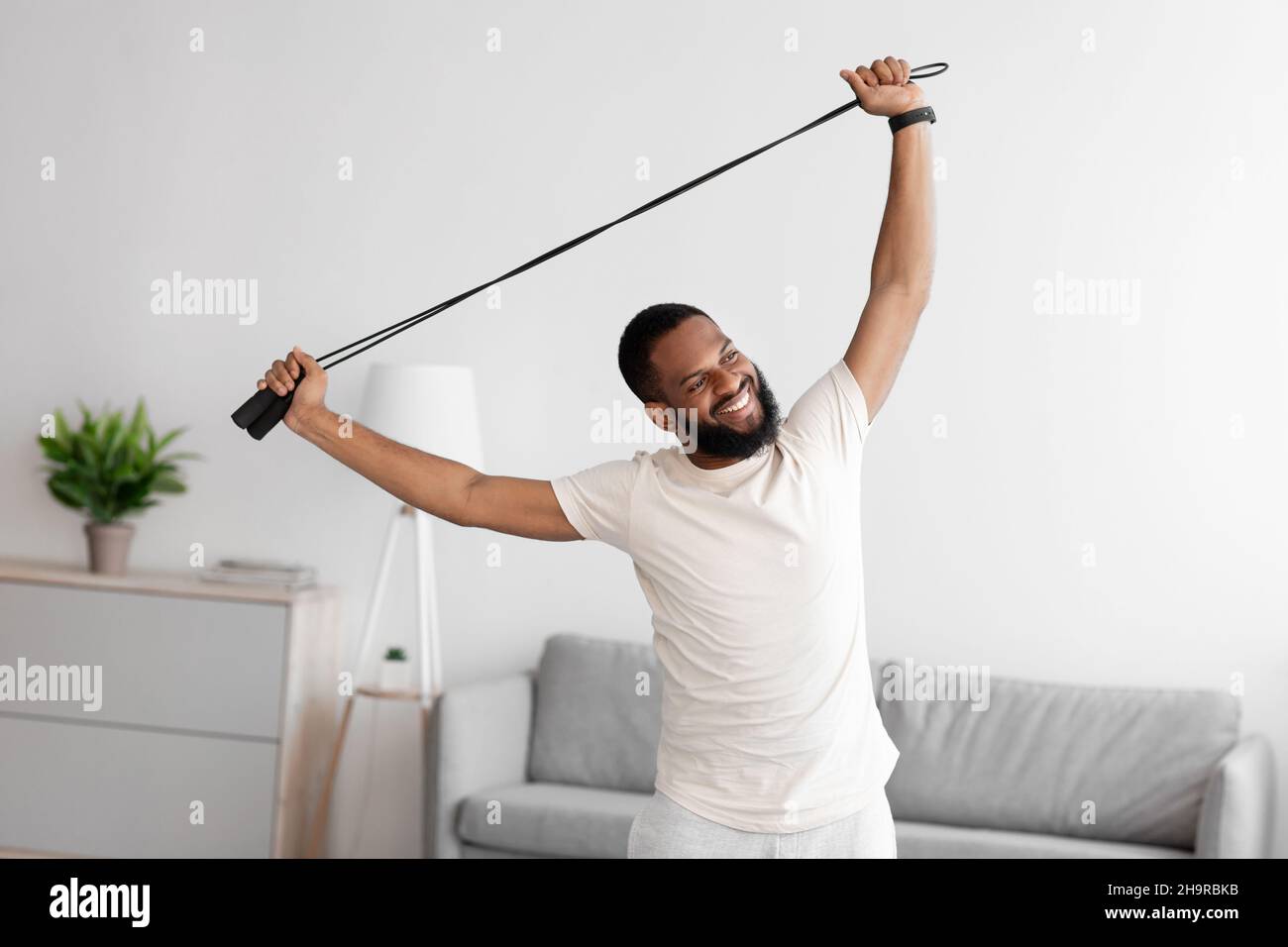 Glad cheerful millennial african american bearded guy doing exercises ...