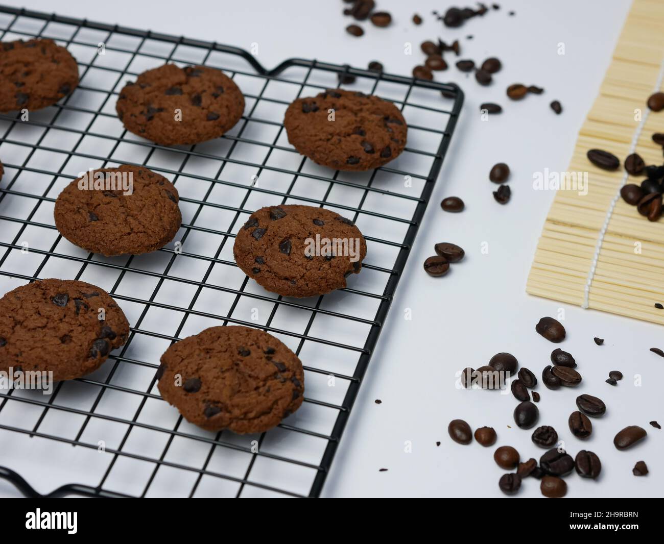 chocolate chip cookies on a grill with coffee beans on a white ...