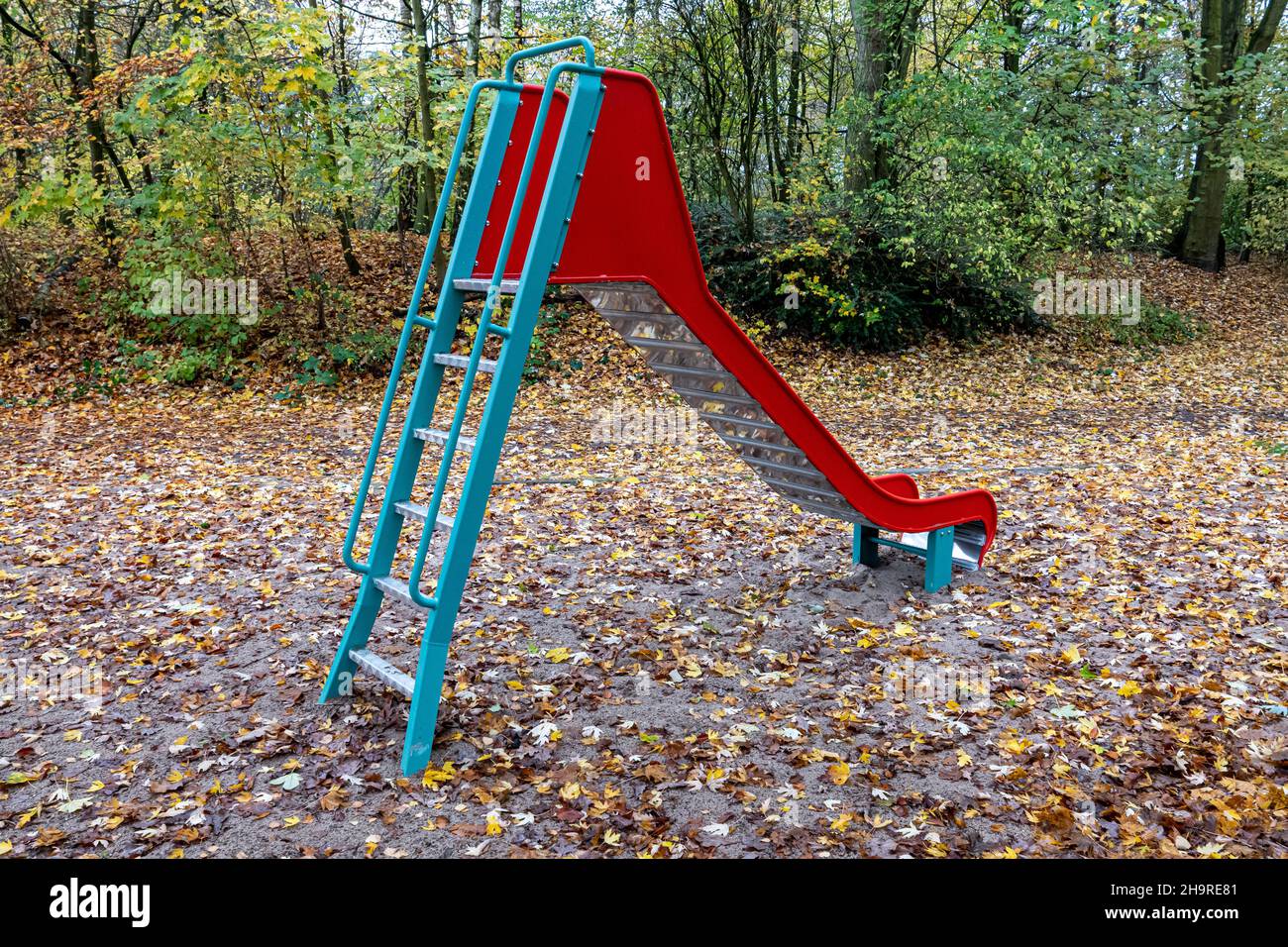 Blue and red metal slide in a park for children Stock Photo - Alamy