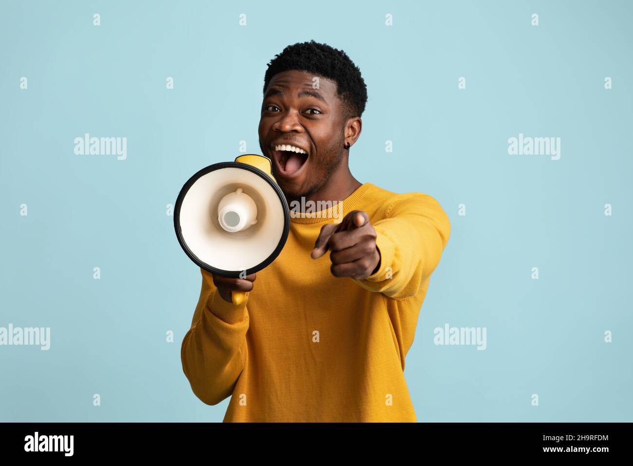 Emotional black guy with megaphone making announcement Stock Photo - Alamy