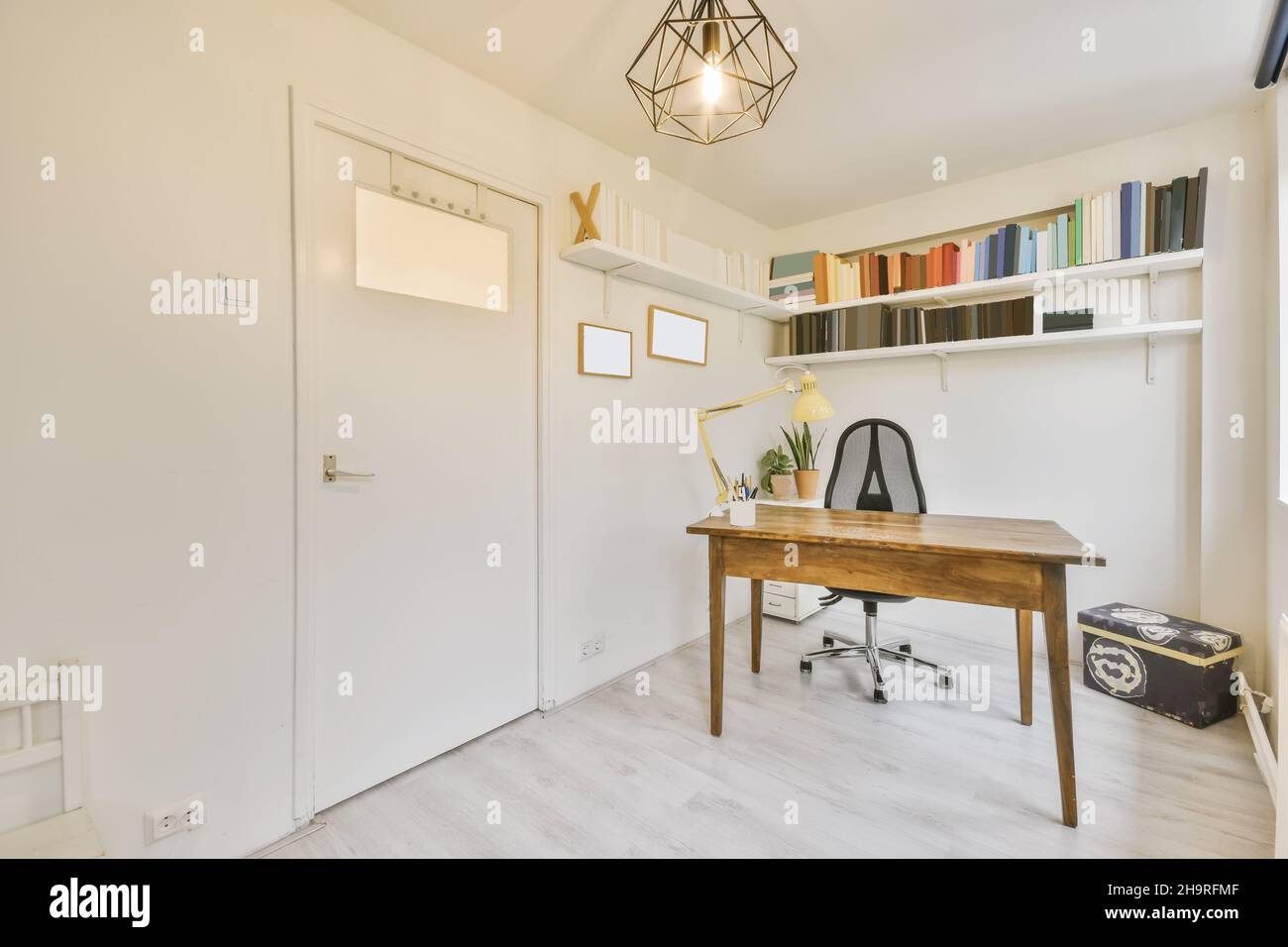 Cozy study area with wooden table and comfortable black chair Stock ...