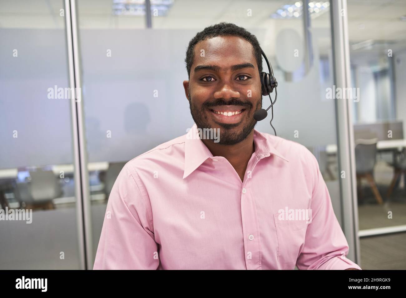 African businessman as a smiling customer service representative with ...