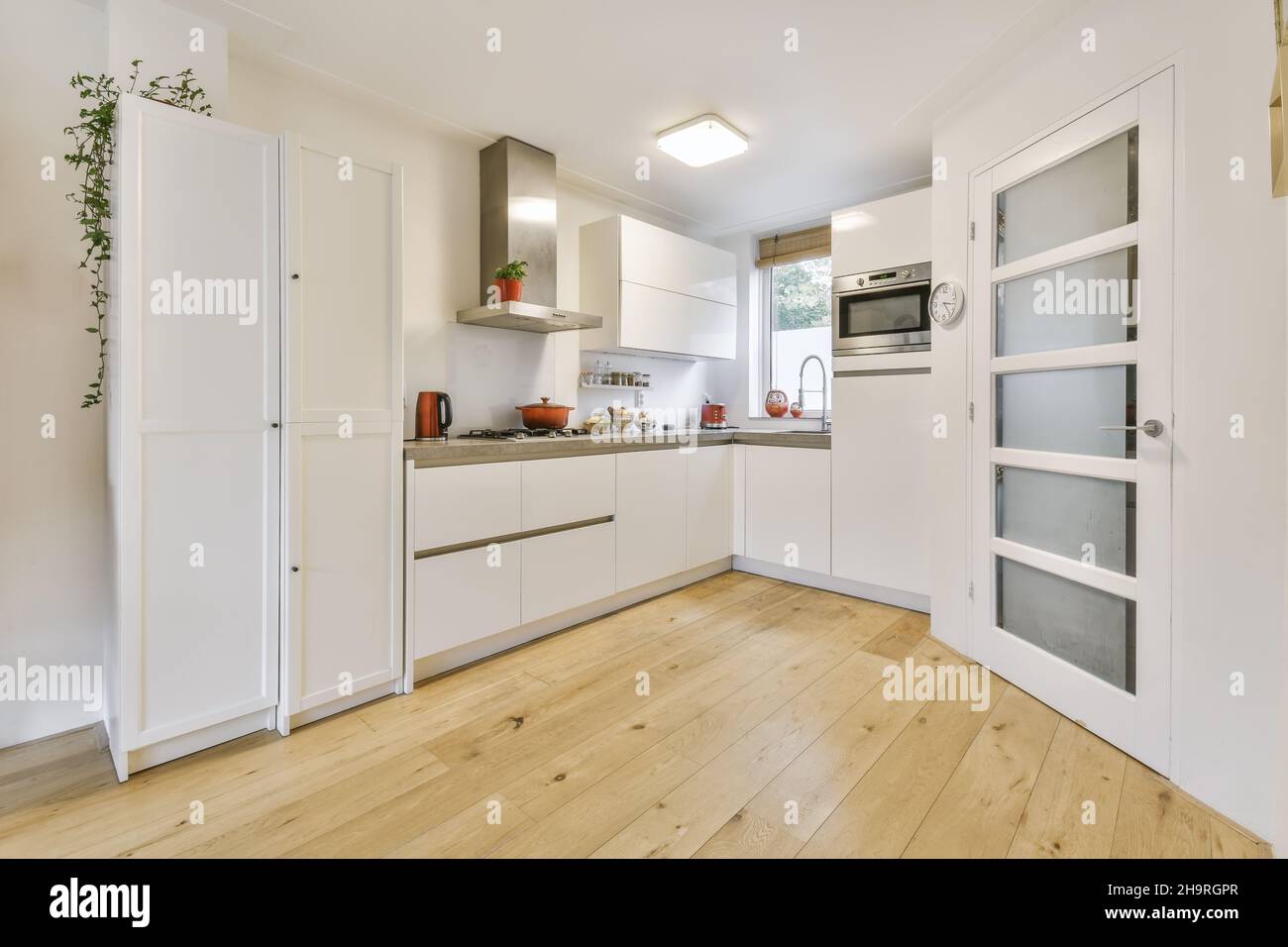 Cozy daylight kitchen with white cabinets and hardwood floors Stock ...