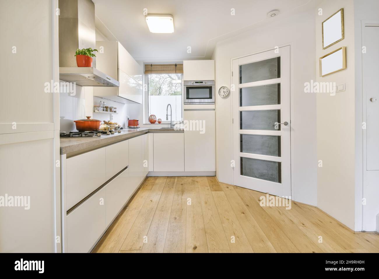 Cozy daylight kitchen with white cabinets and hardwood floors Stock ...