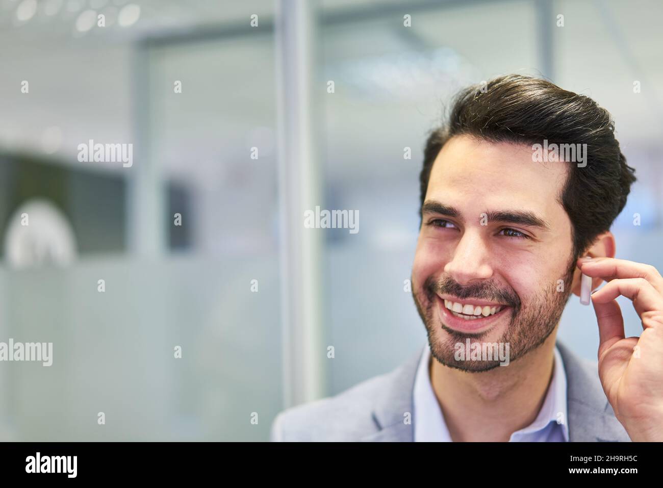 Satisfied business man as a successful start-up founder uses bluetooth ...