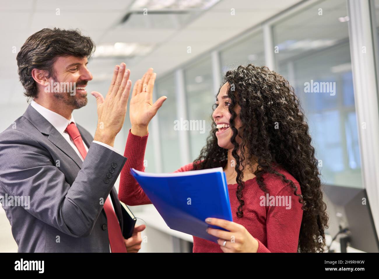 Two start-up business people give each other a high five for greeting ...