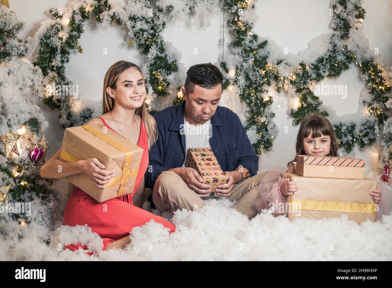 New Year photo of happy mixed family with cute daughter. Giving ...