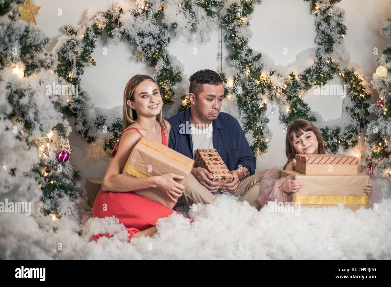 New Year photo of happy mixed family with cute daughter. Giving ...