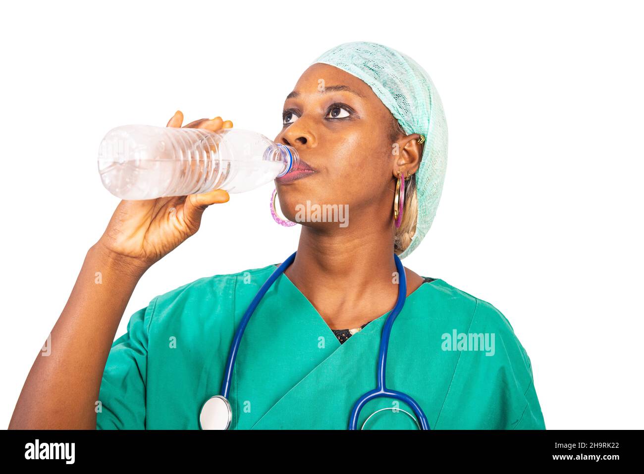 beautiful young woman doctor drinking mineral water in a plastic bottle ...
