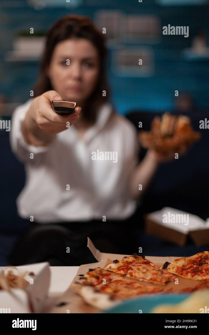 Selective focus on woman hand holding television remote control to ...