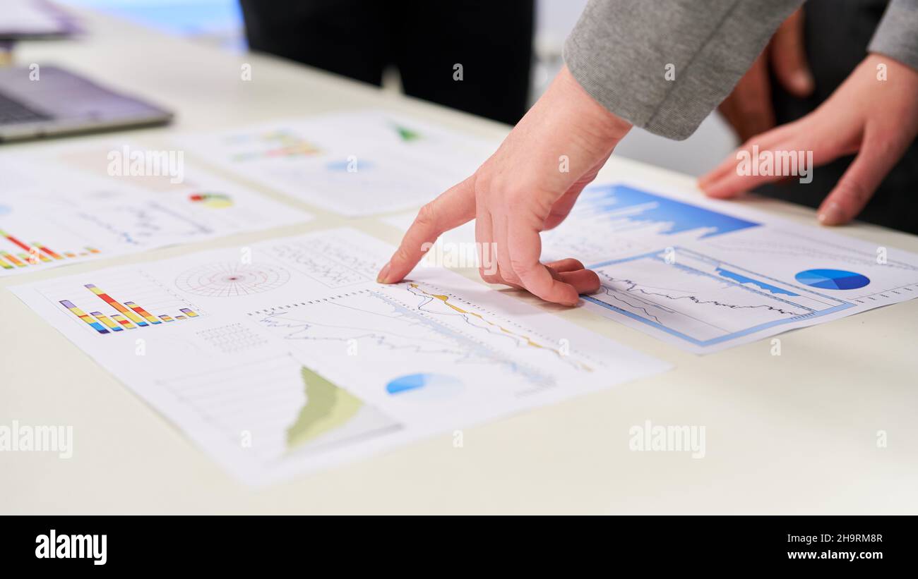 Hand of business man pointing to data with charts in financial analysis ...